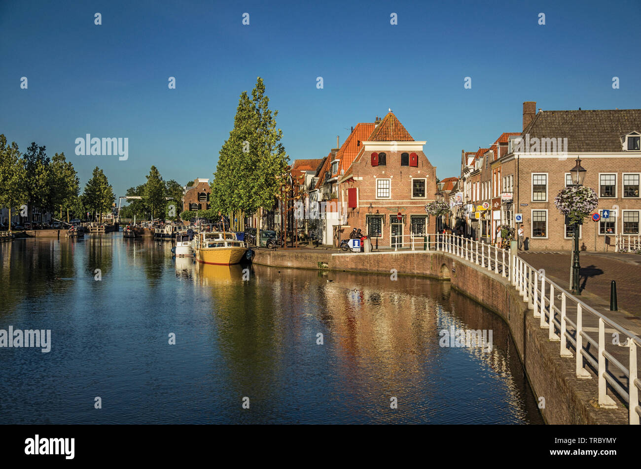 Street and bridge over the canal, moored boats and brick houses at ...