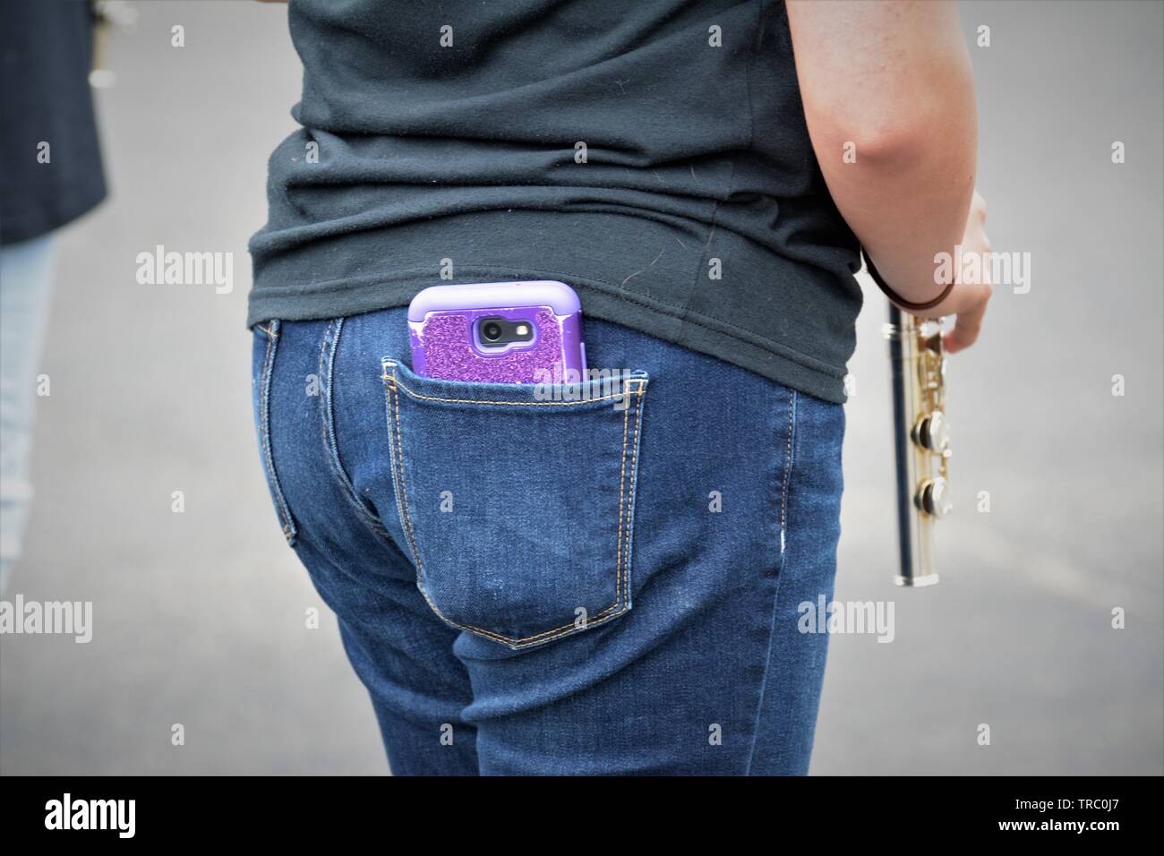 Girl with cell phone in her back pocket at parade where she is in a ...