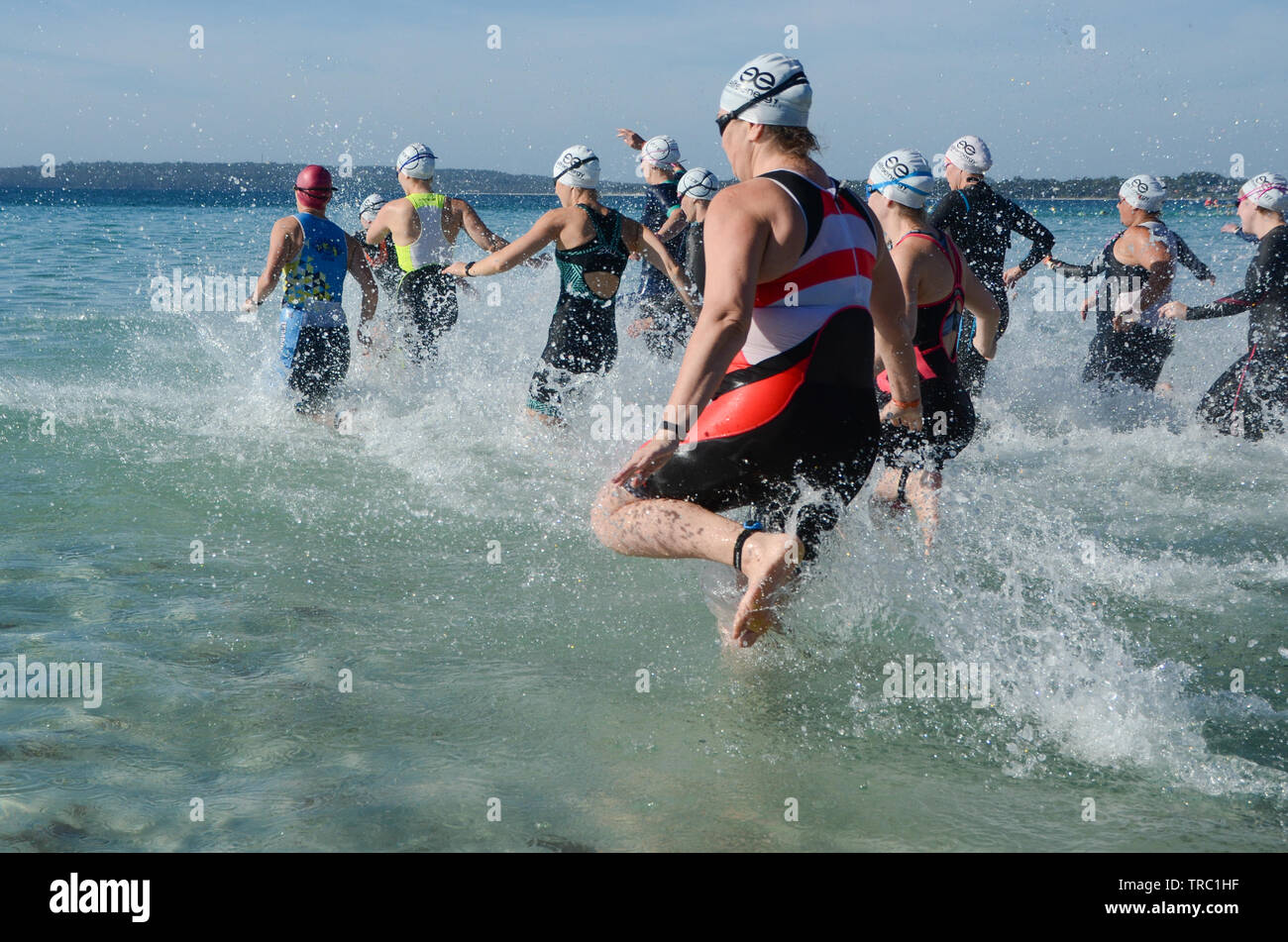 Women competitors race into water at start of swim leg of beach side ...