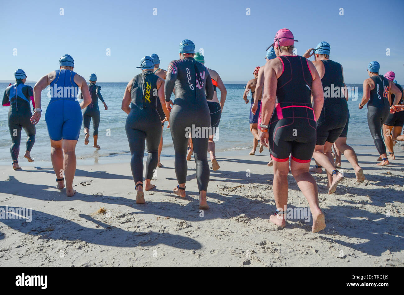 Women competitors race into water at start of swim leg of beach side ...