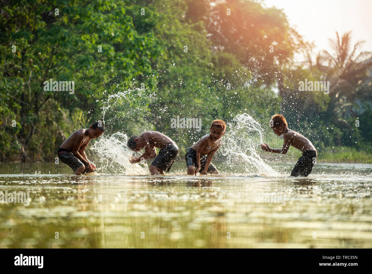 Asia children on river / The boy friend happy funny playing water in ...