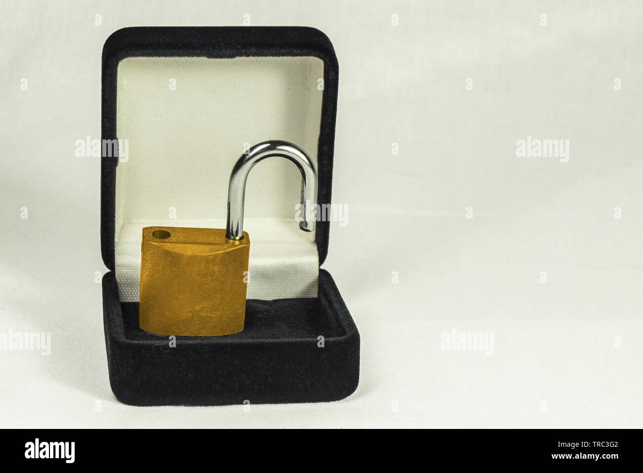 Lock in gift box. Gold padlock with open shackle in jewelry chest ...