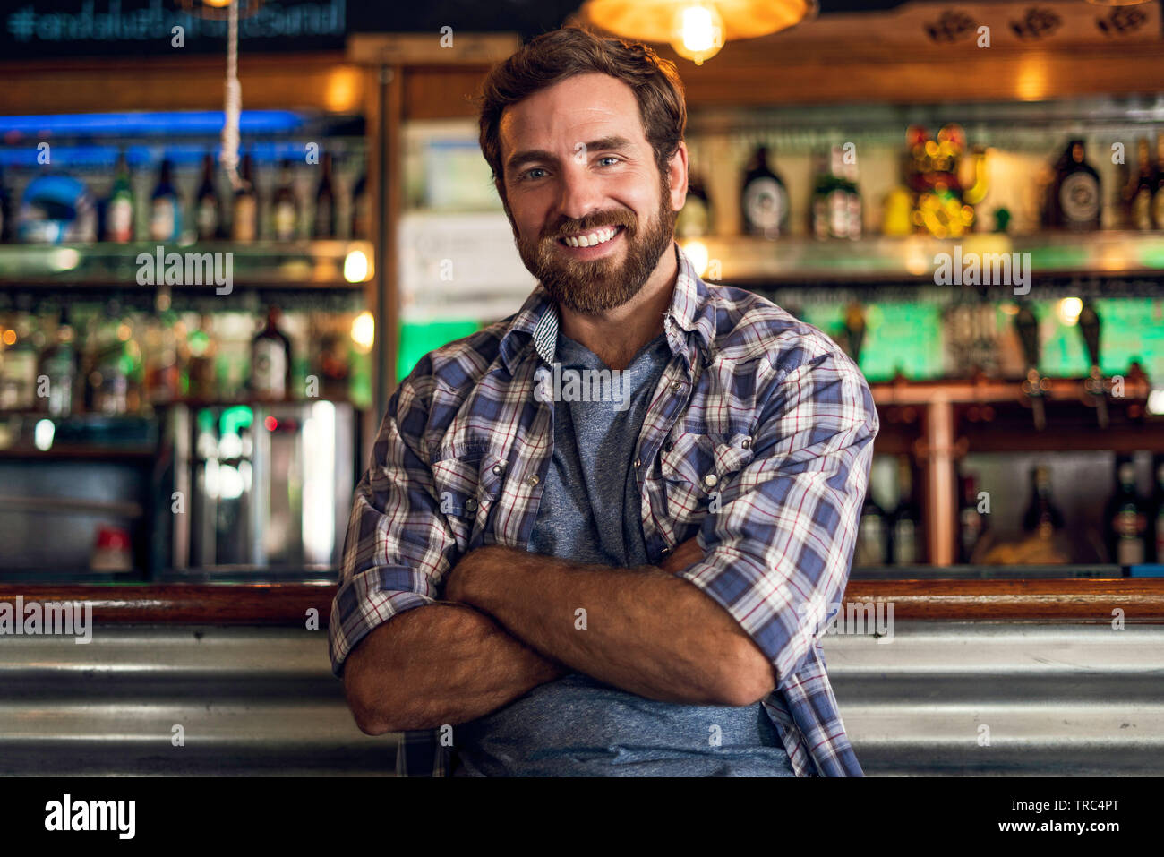 Portrait of smiling man leaning against bar counter Stock Photo - Alamy