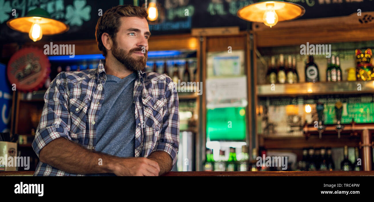 Man leaning against bar counter Stock Photo - Alamy