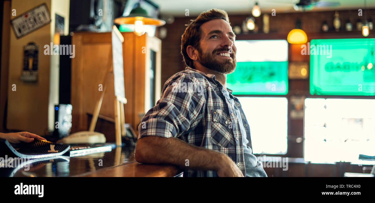 Man leaning against bar counter Stock Photo - Alamy