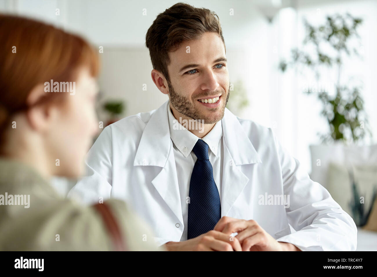 Smiling doctor talking with patient Stock Photo - Alamy