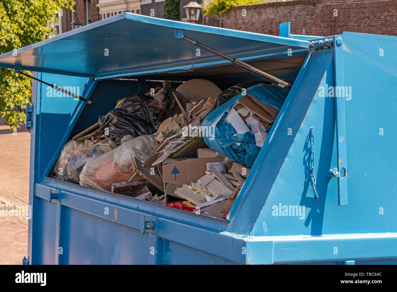 blue waste container with open flap full of waste Stock Photo - Alamy