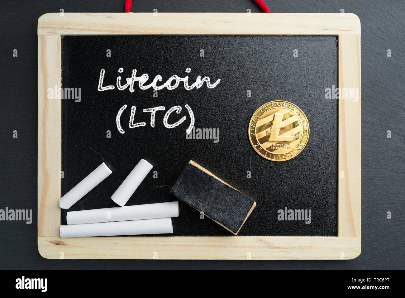 Physical Litecoin gold coin on a blackboard with chalk text ...