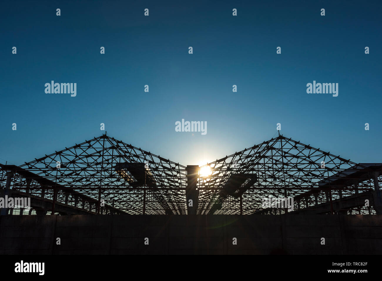 Sunset behind framework of abandoned factory roof Stock Photo - Alamy