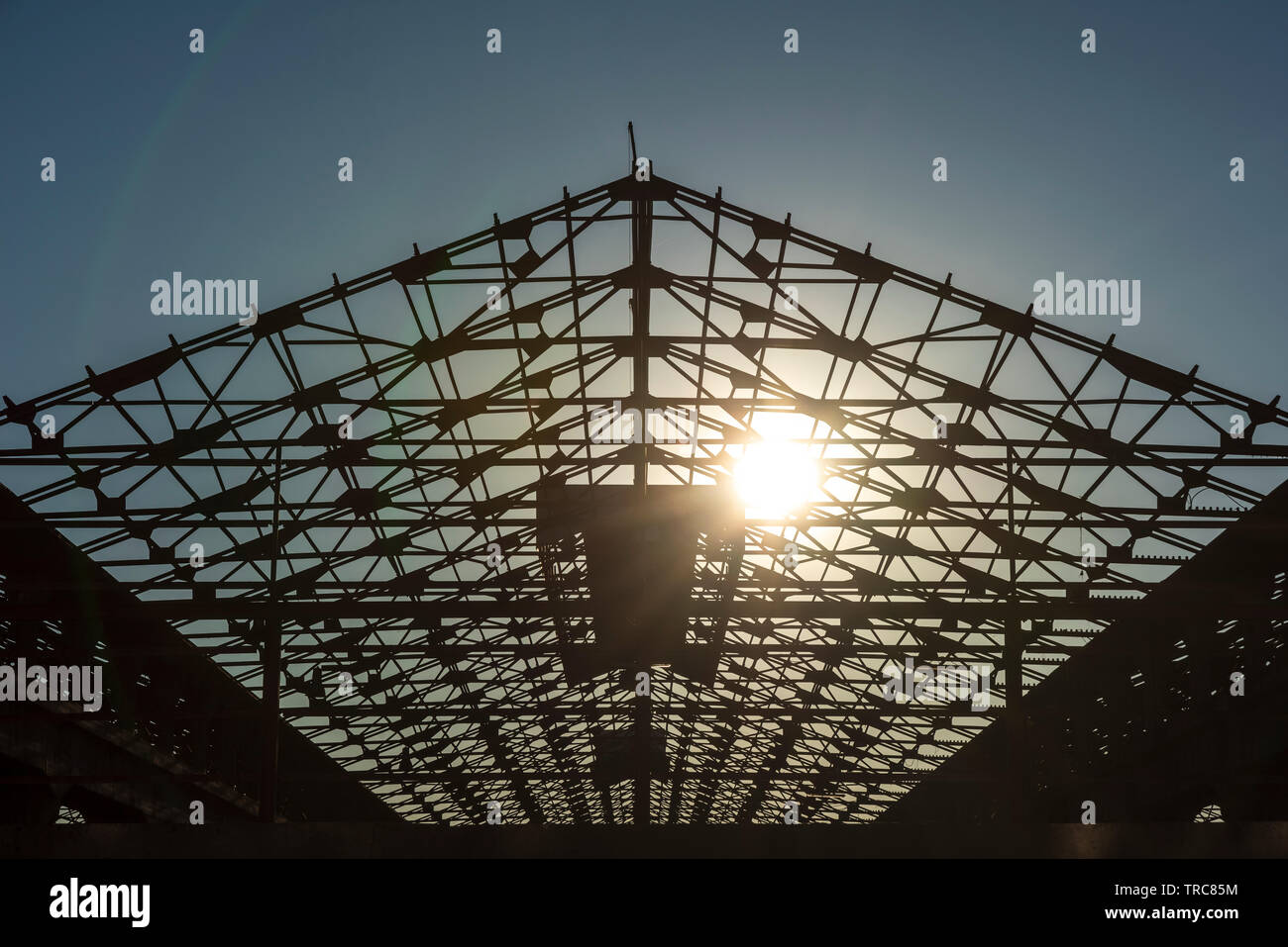 Sunset behind framework of abandoned factory roof Stock Photo - Alamy