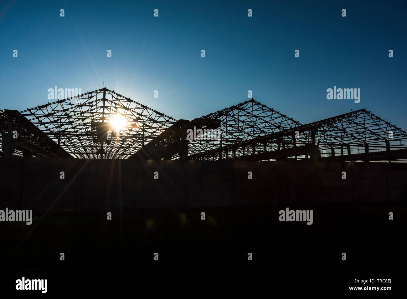 Sunset behind framework of abandoned factory roof Stock Photo - Alamy