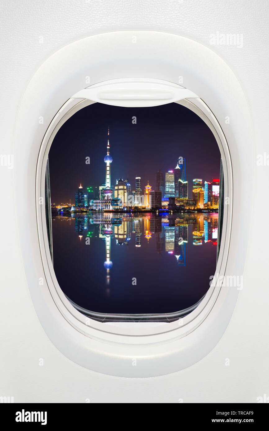 Shanghai at night seen through the window of airplane, travel in China ...