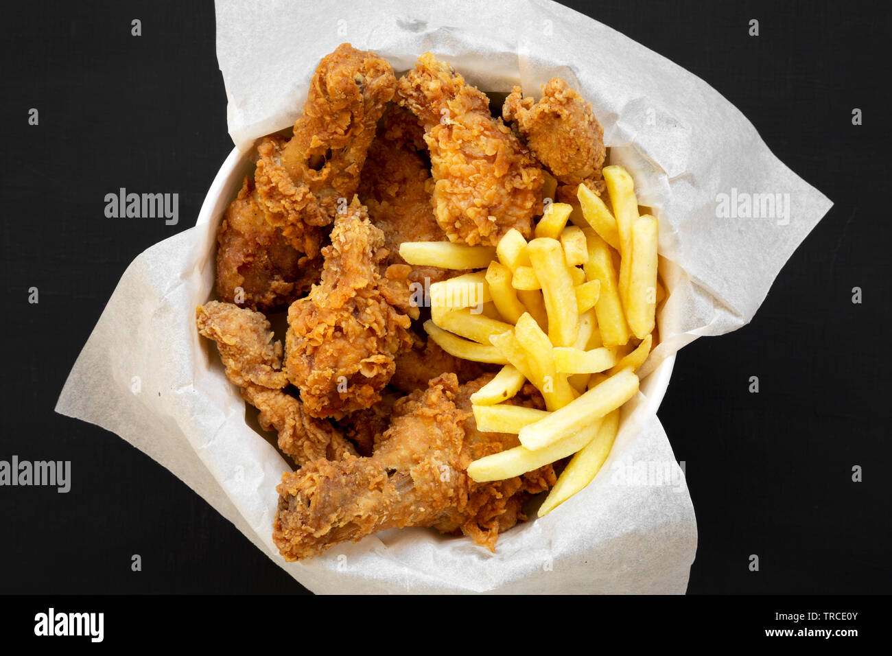 Overhead view, fried chicken drumsticks, spicy wings, French fries and ...