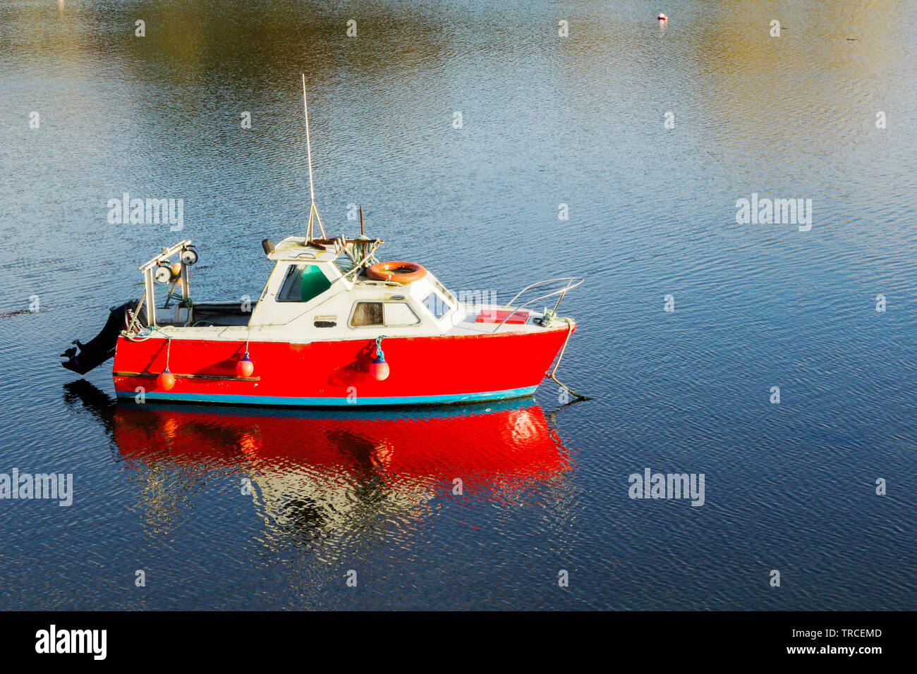 Picture of a small red boat floating on the calm water Stock Photo - Alamy
