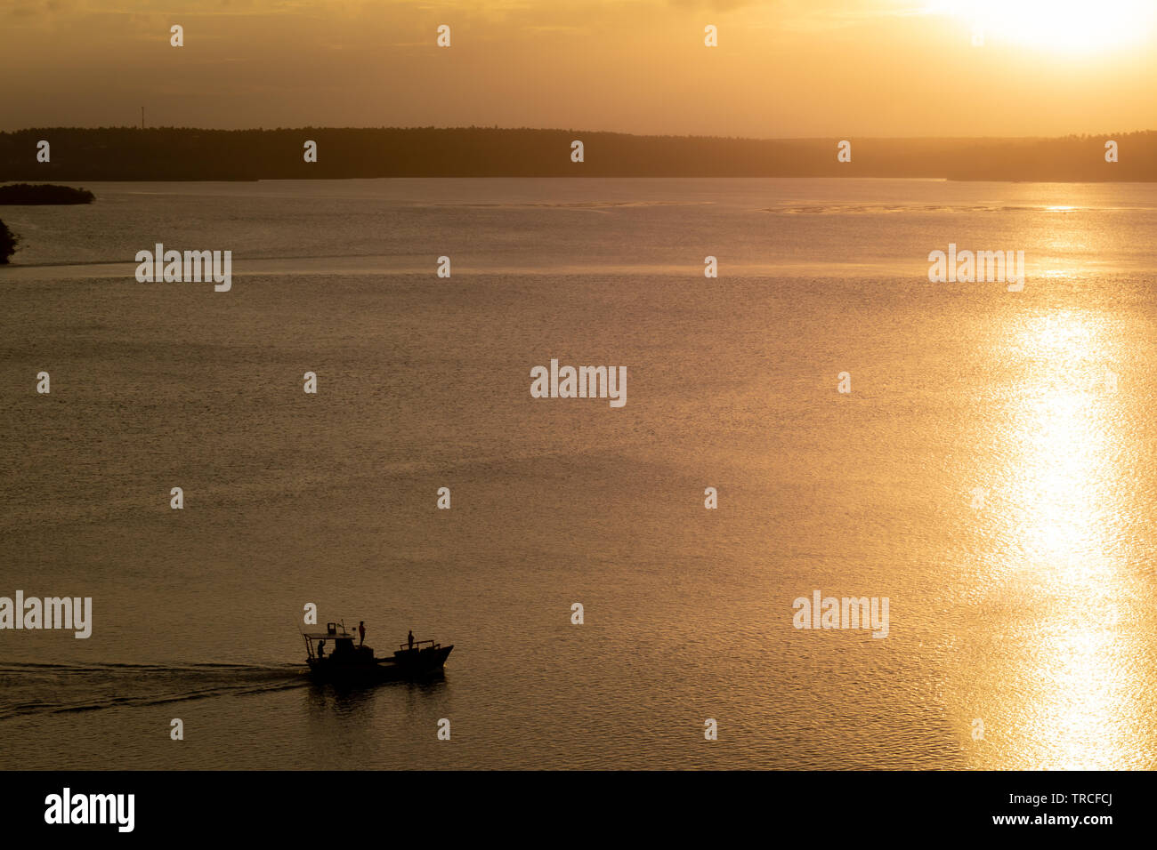 During sunset, a small barge navigates the lake. Landscape of warm ...
