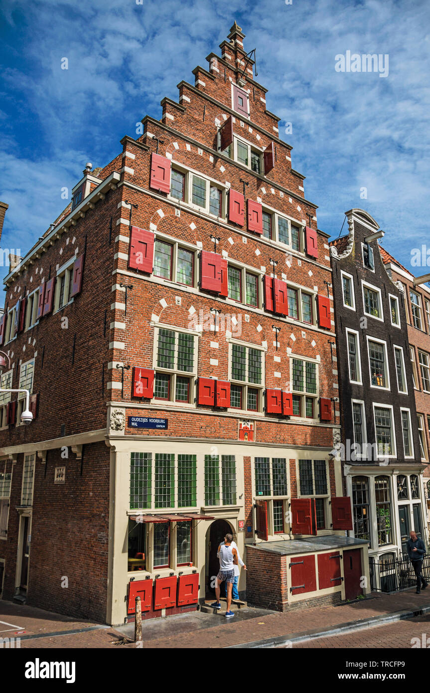 Brick buildings facade and people under sunny blue sky in Amsterdam ...
