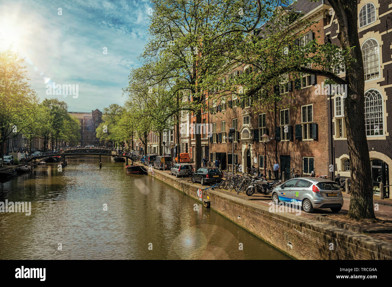 Canal with old brick buildings, bridge and sunny day in Amsterdam. City ...