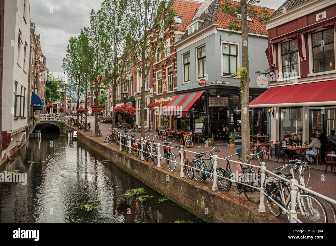Shopping street with eateries, canal, brick buildings and bicycles in ...