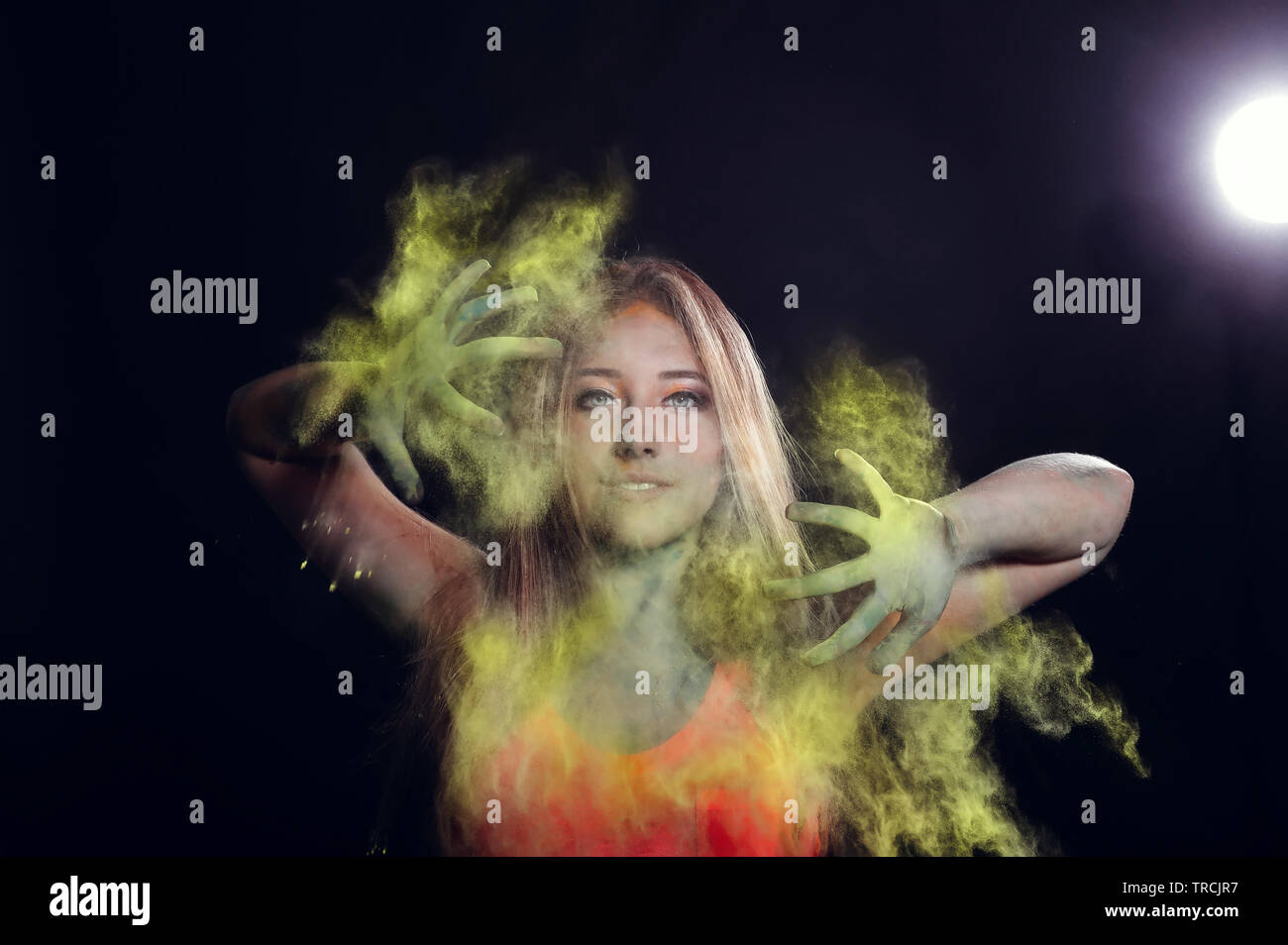 girl with colored powder exploding around her and into the background ...