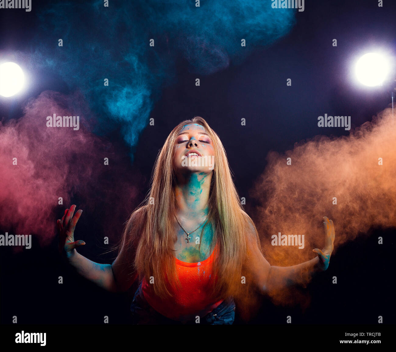 girl with colored powder exploding around her and into the background ...
