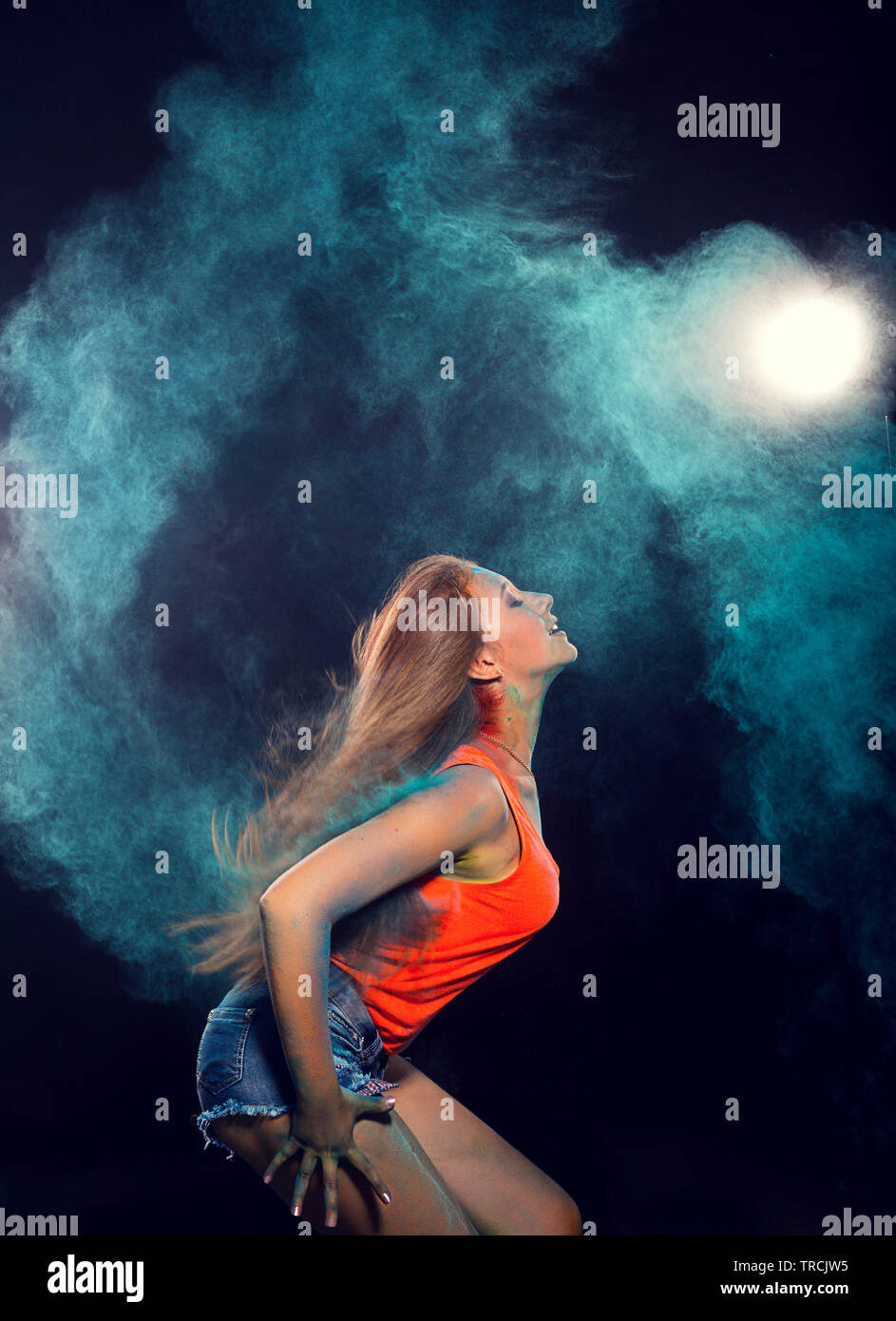 girl with colored powder trailing behind her hair that she is flinging ...
