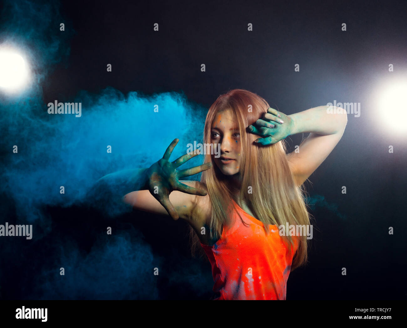 girl with colored powder exploding around her and into the background ...