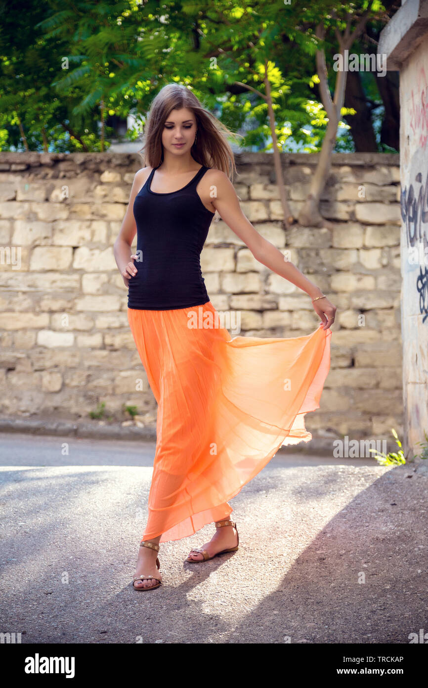 Beautiful city woman has walking on a street. The girl in the sunset ...