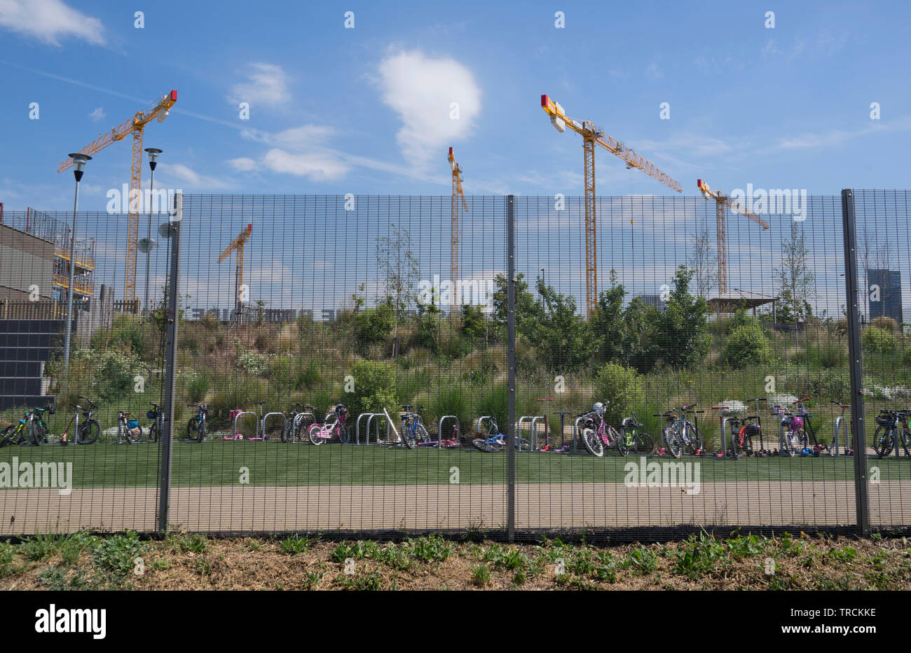 School playground with building cranes in background along canal ...