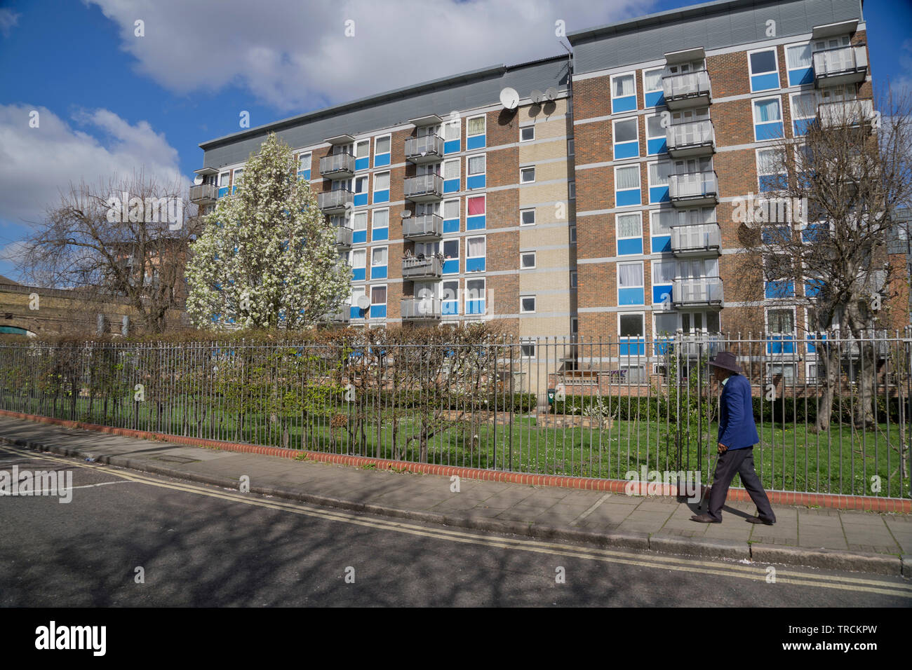 Neighbour walks past a run-down council housing estate in east London ...