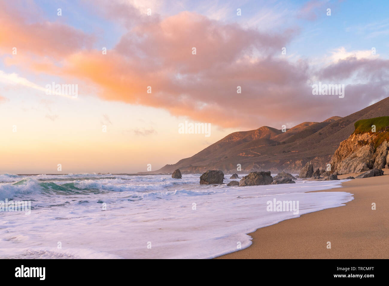 Sunset along a sandy beach with mountains in the along the coast in Big ...