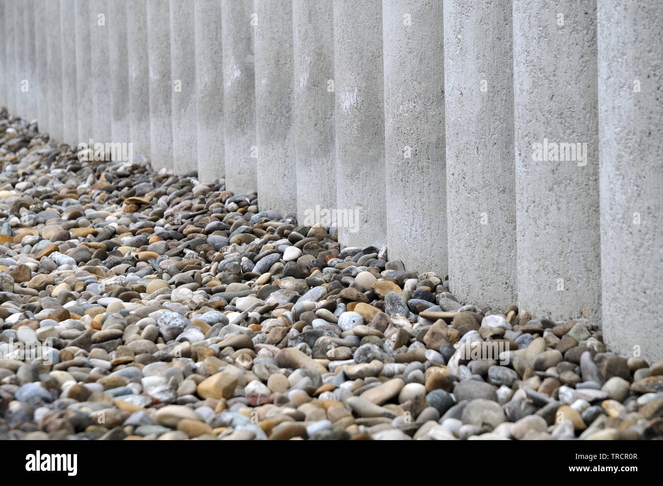 side view to a concrete wall with pebbles lying beside Stock Photo - Alamy