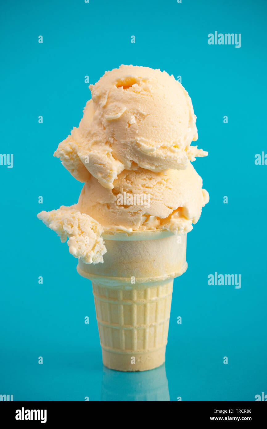 Double Scoop Vanilla Ice Cream Cone on a Blue Background Stock Photo ...