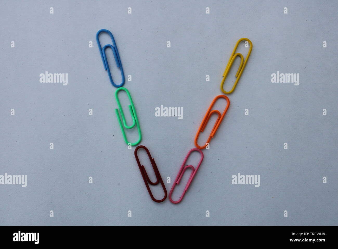 Letter V made with colorful paper clips on white background Stock Photo ...