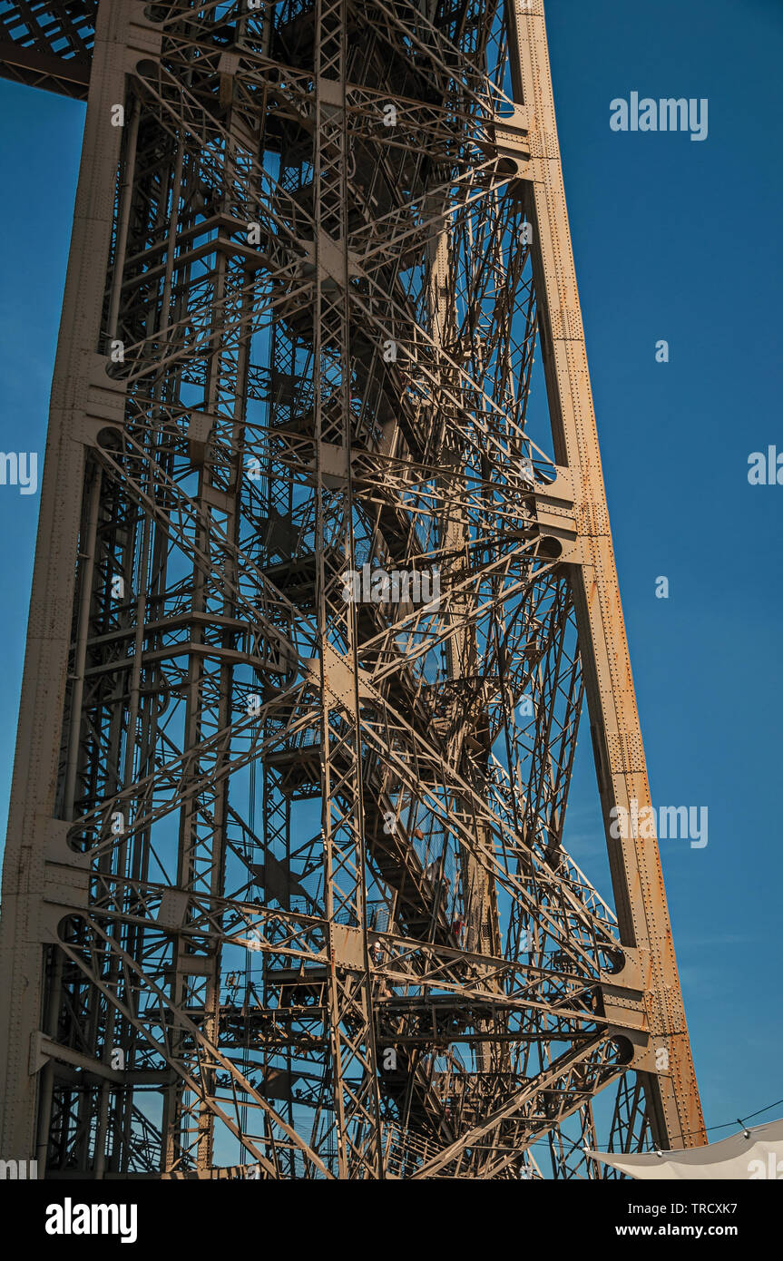 View of one leg’s iron structure of the Eiffel Tower, with sunny blue ...