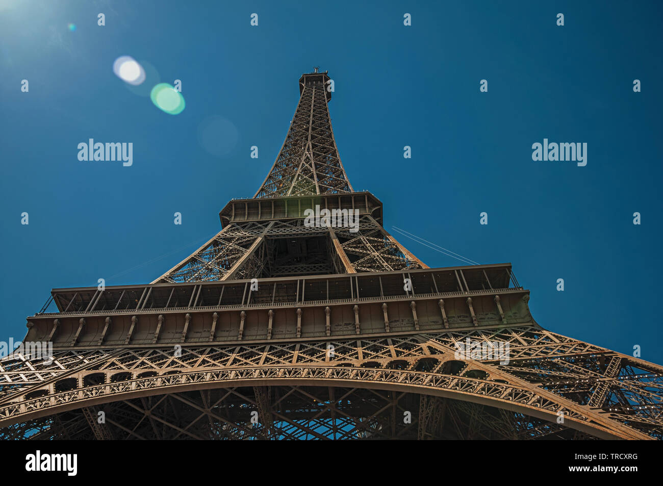 View of the Eiffel Tower all made of iron with blue sky and sunshine in ...
