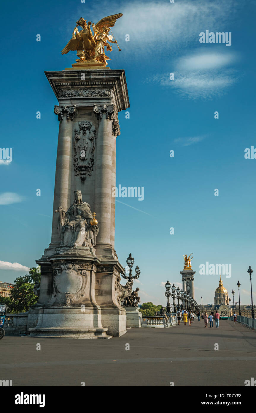 Marble column with golden statue adorning a bridge over the Seine River ...