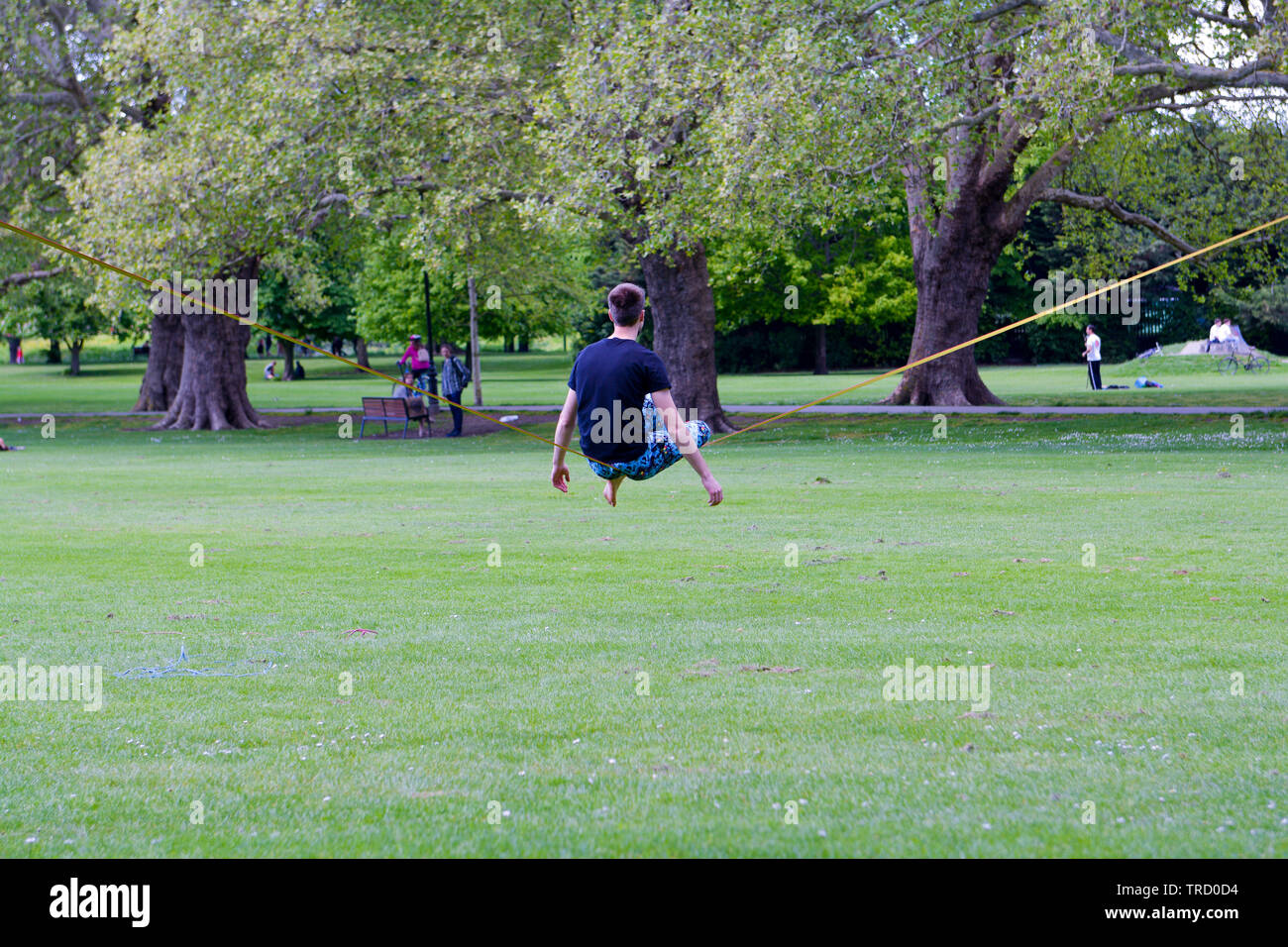 cambridge uk 2019-05-12. A male practises balancing on a slack line ...