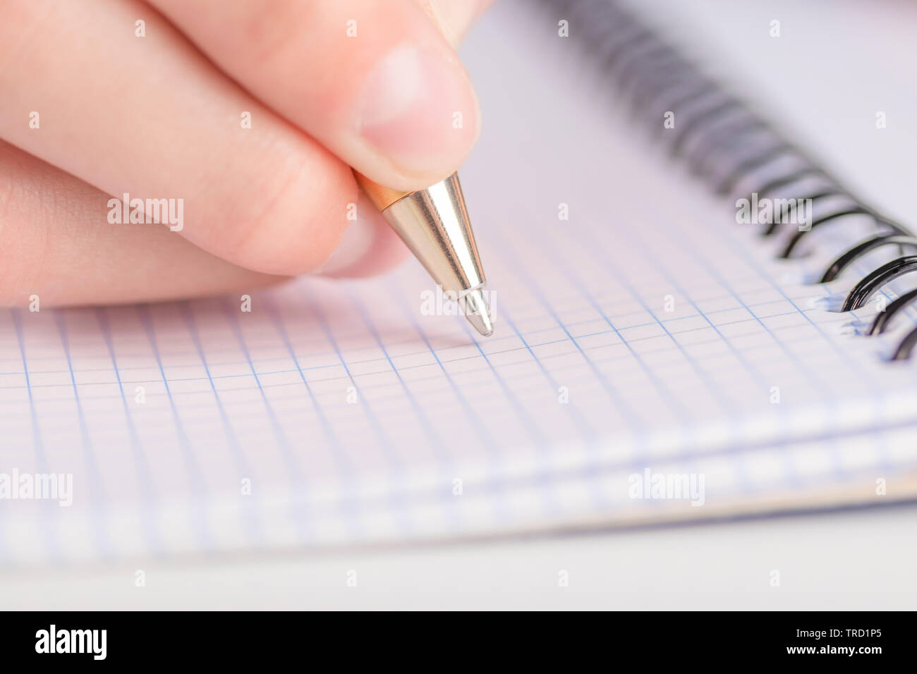 Teen writes black yellow pen in a checkered notebook. Homework and ...