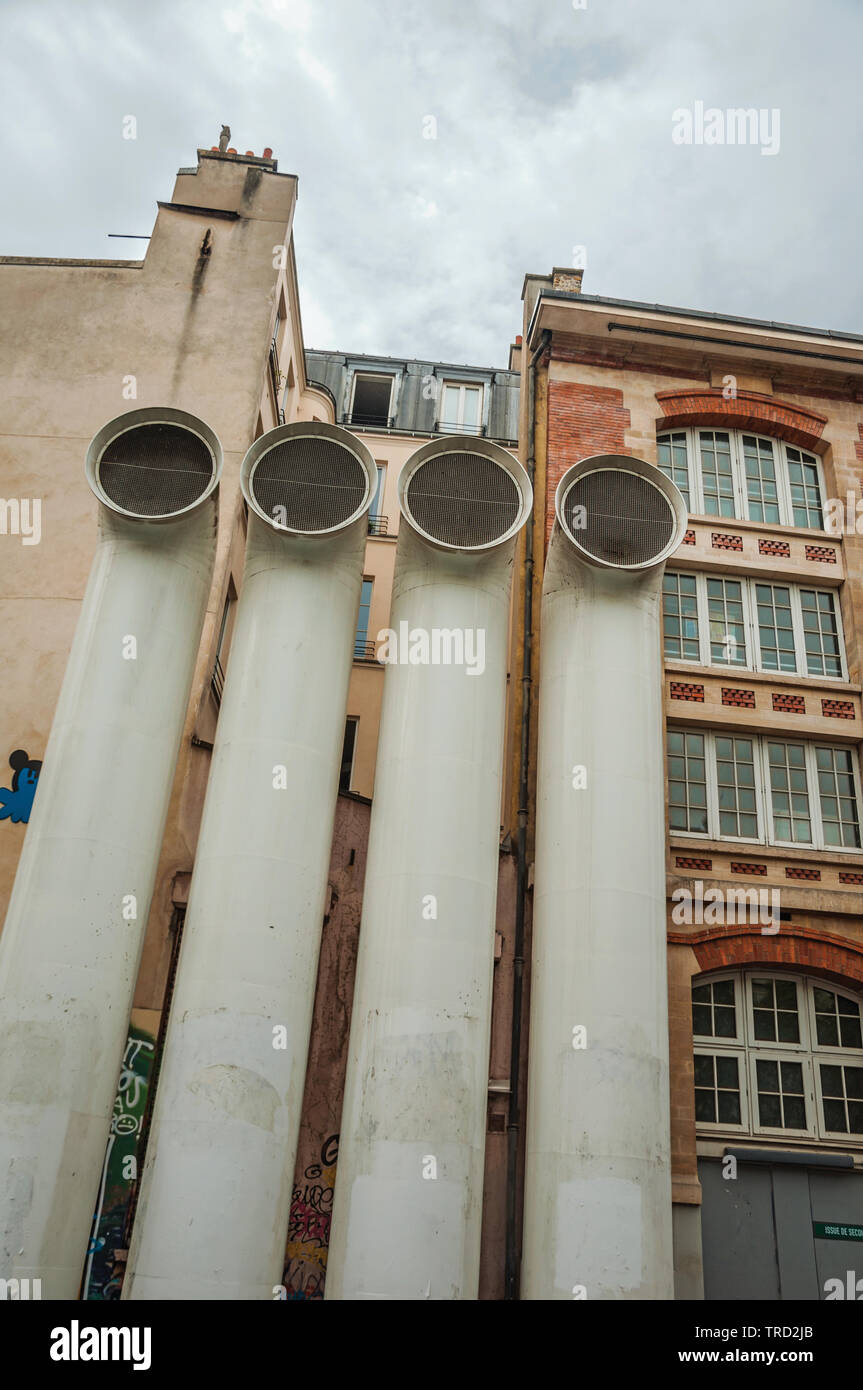 Exhaust pipelines in front of building on cloudy and rainy day in Paris ...