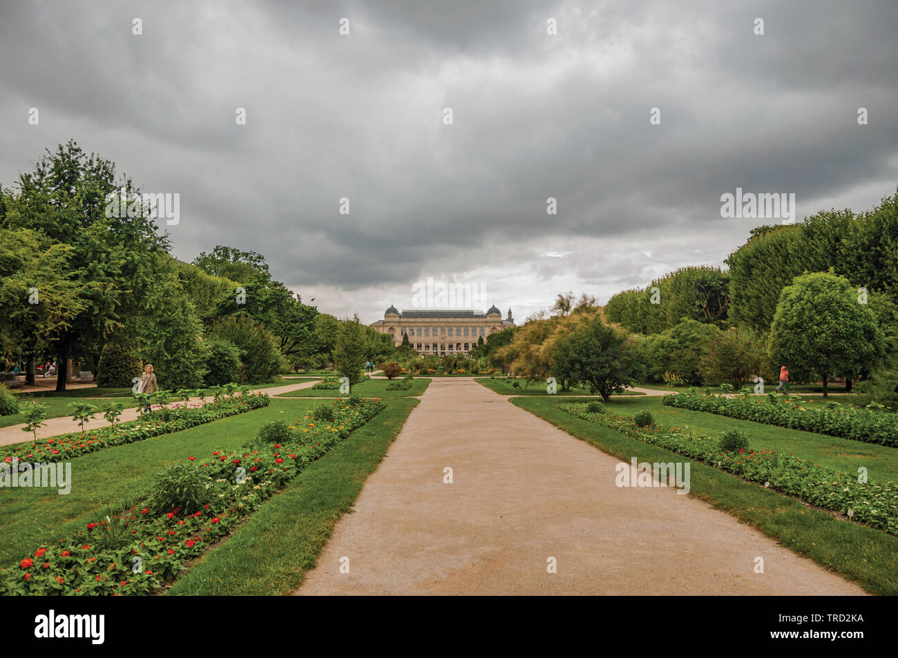 Path on flowered yard with people and old building at the Garden of ...