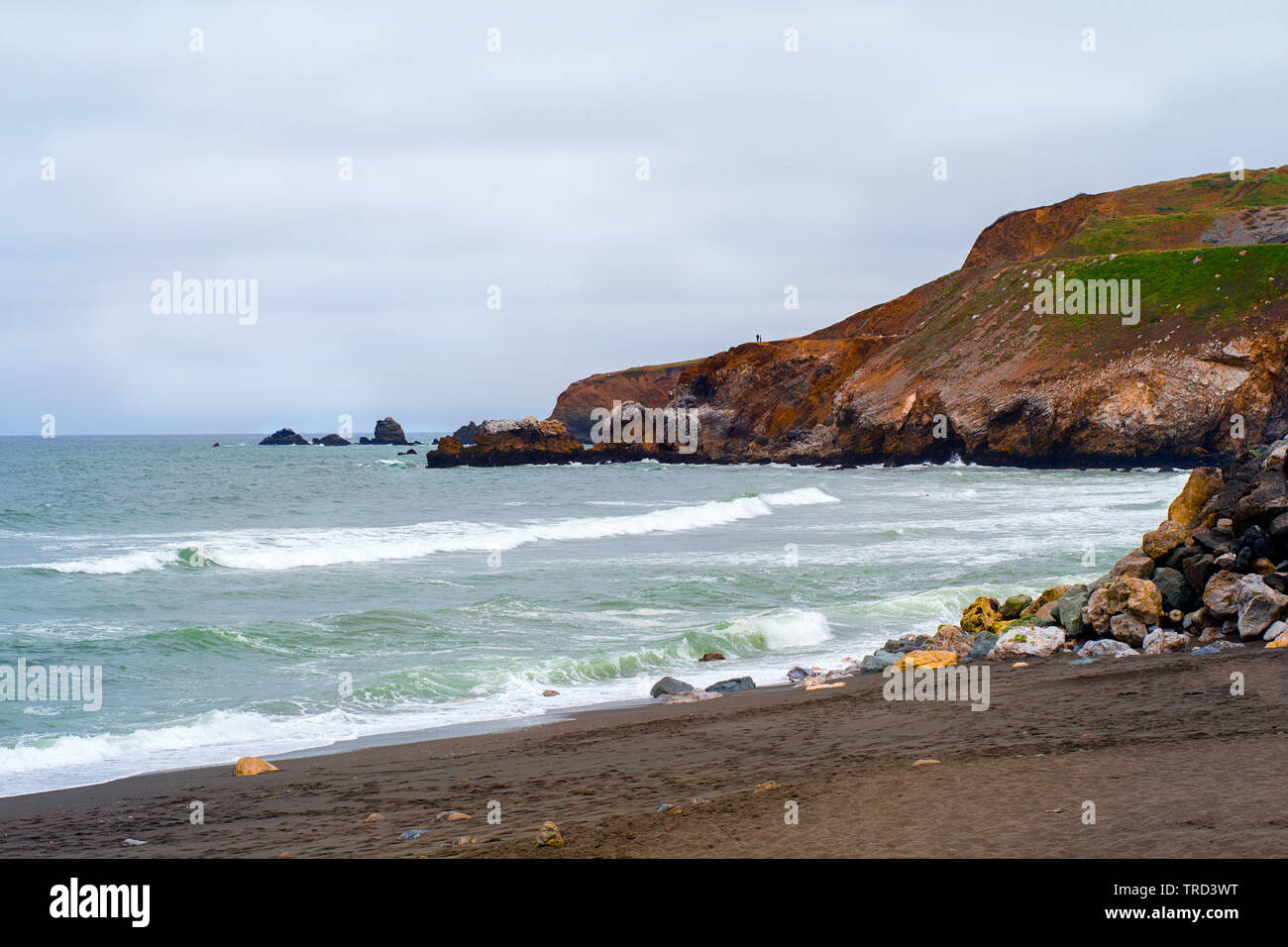 Photo of a Sandy and Rocky Beach, Surrounded by Tall Hiking Cliffs at ...