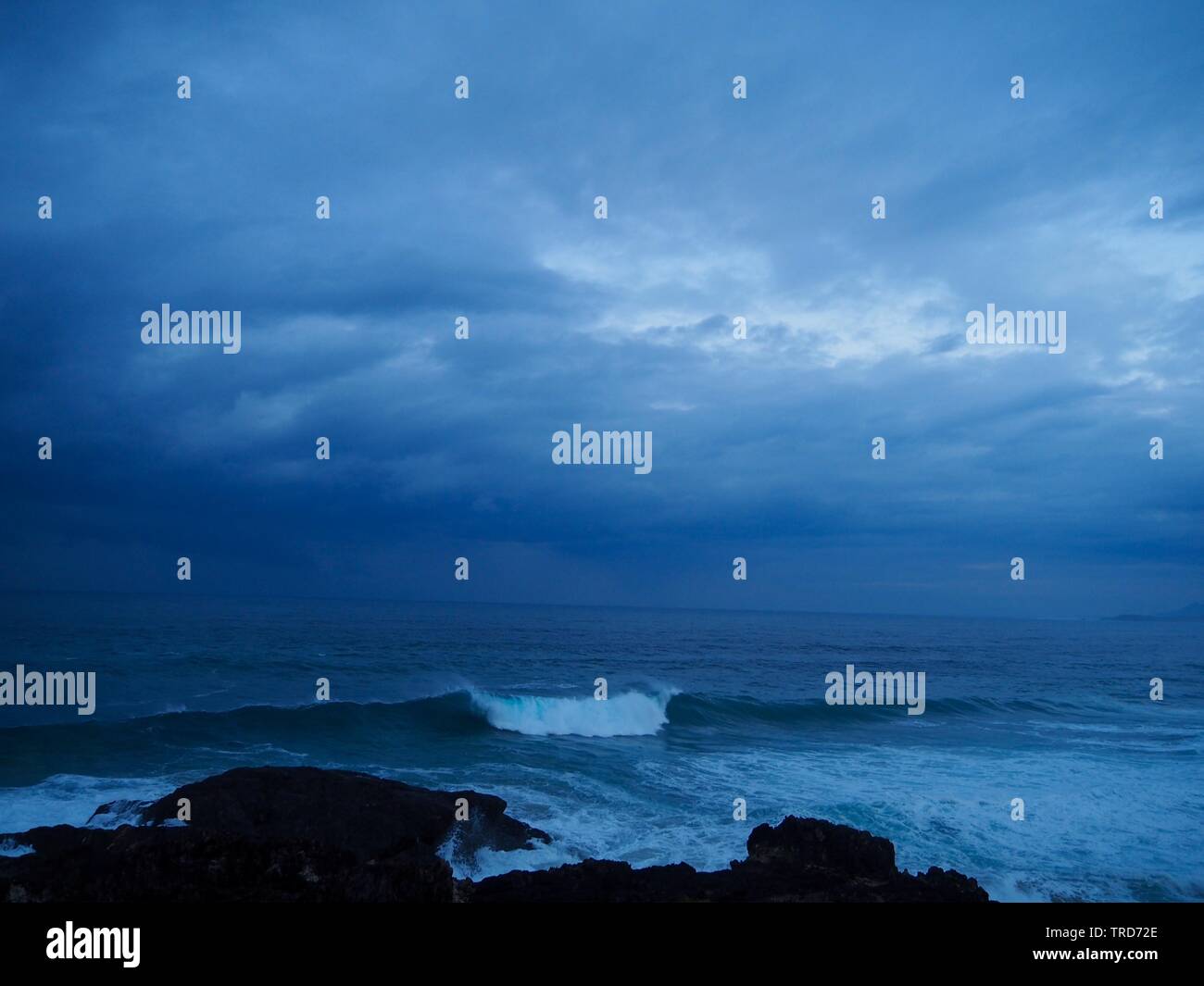 The deep dark shades of blue colours of a stormy seascape, storm clouds ...