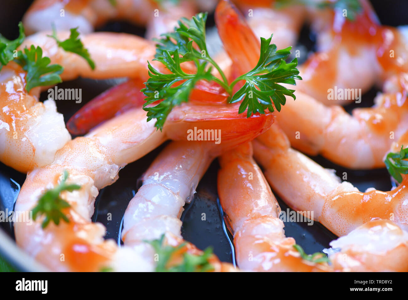 Shrimps prawns seafood cooked on hot pan with curly parsley and ketchup ...