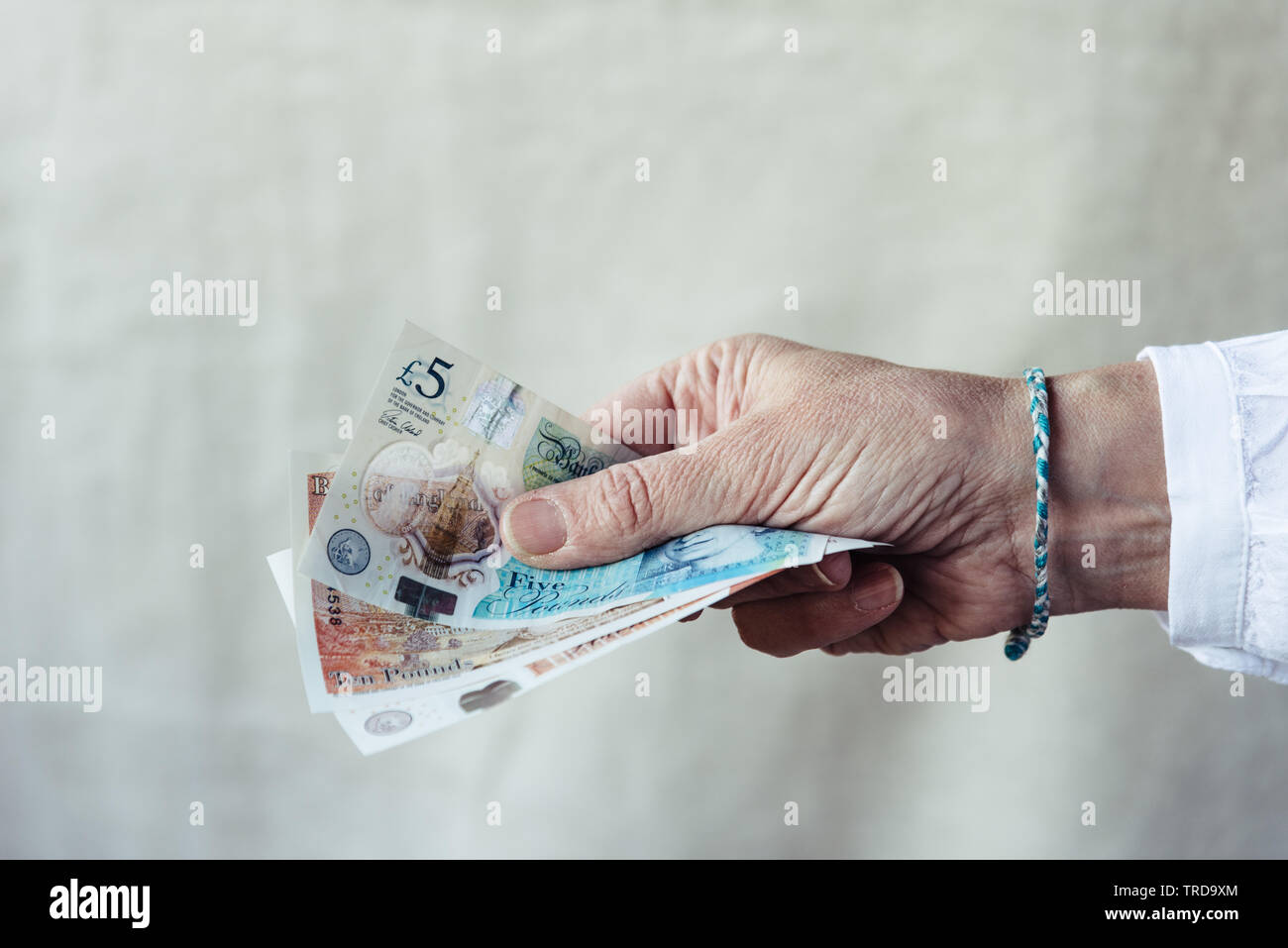 Hand holding british banknotes hi-res stock photography and images - Alamy