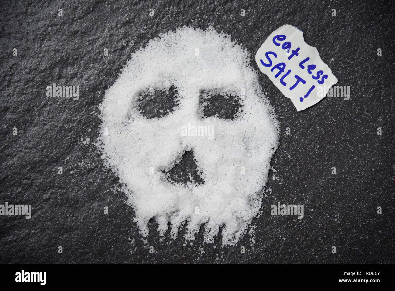 Eat less salt for health concept / Heap of white salt skull shape on ...