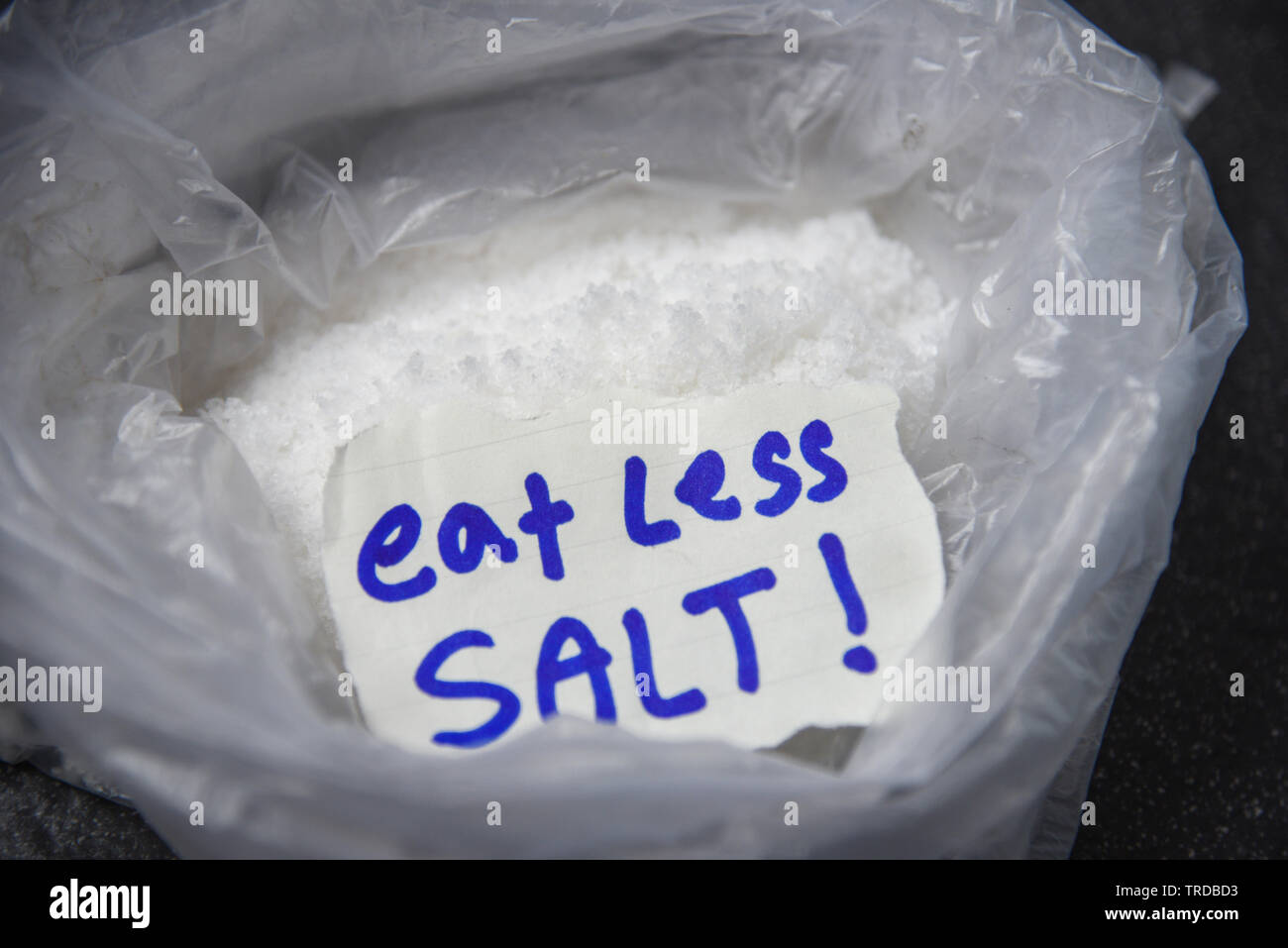 Eat less salt for health concept / Heap of salt in plastic bag ...