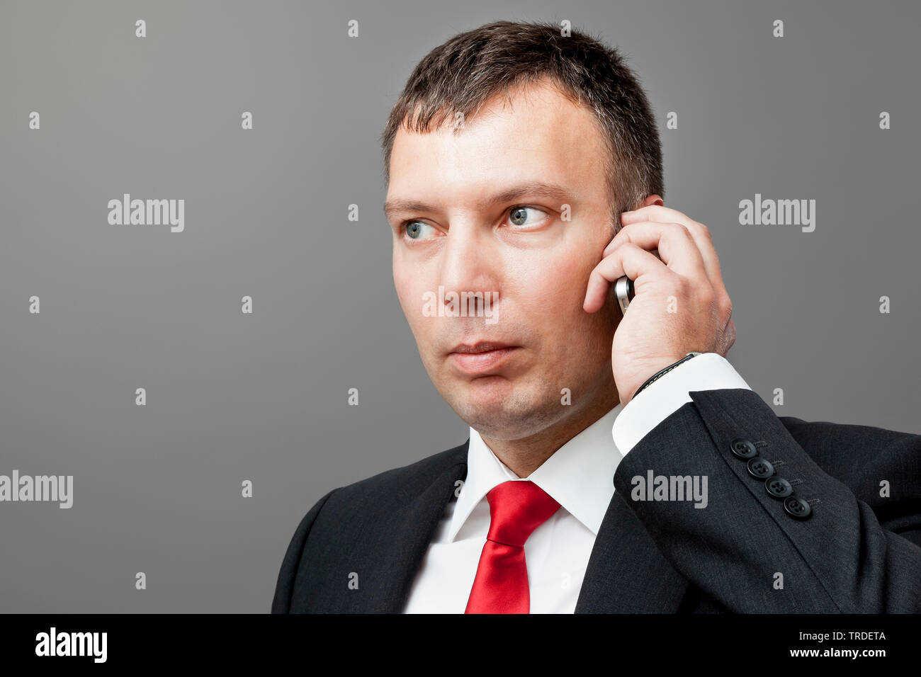 Portrait of a likeable Businessman in a black suit making a phone call ... Portrait of a likeable Businessman in a black suit making a phone call ...