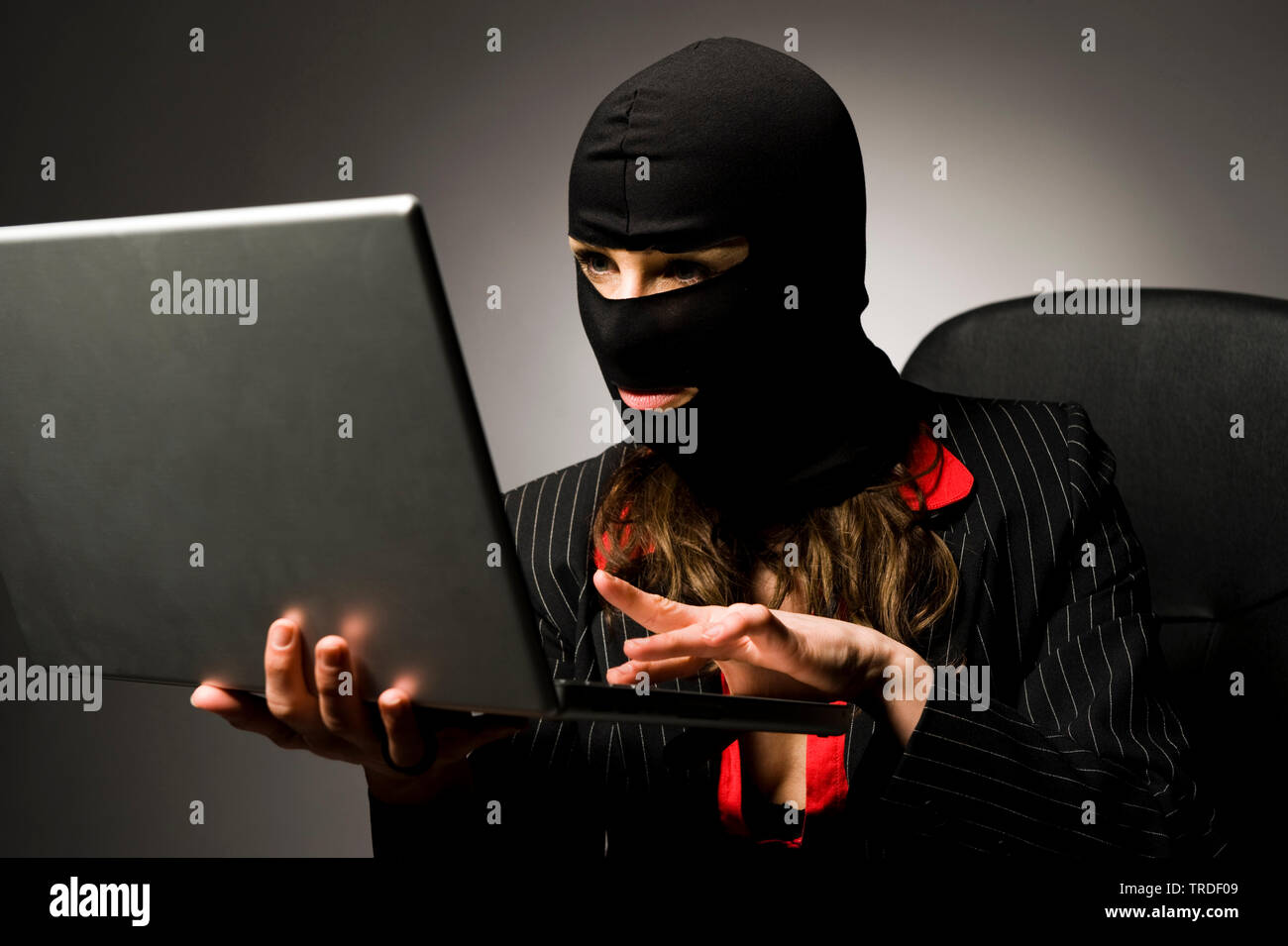 Portrait of an Business woman wearing a ski mask and working with a ...