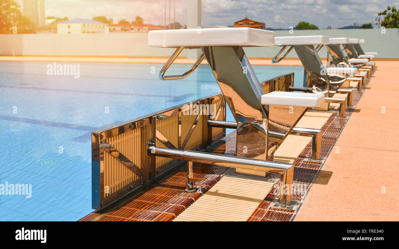 Starting position swimming pool with blue water surface stair grab bars ...
