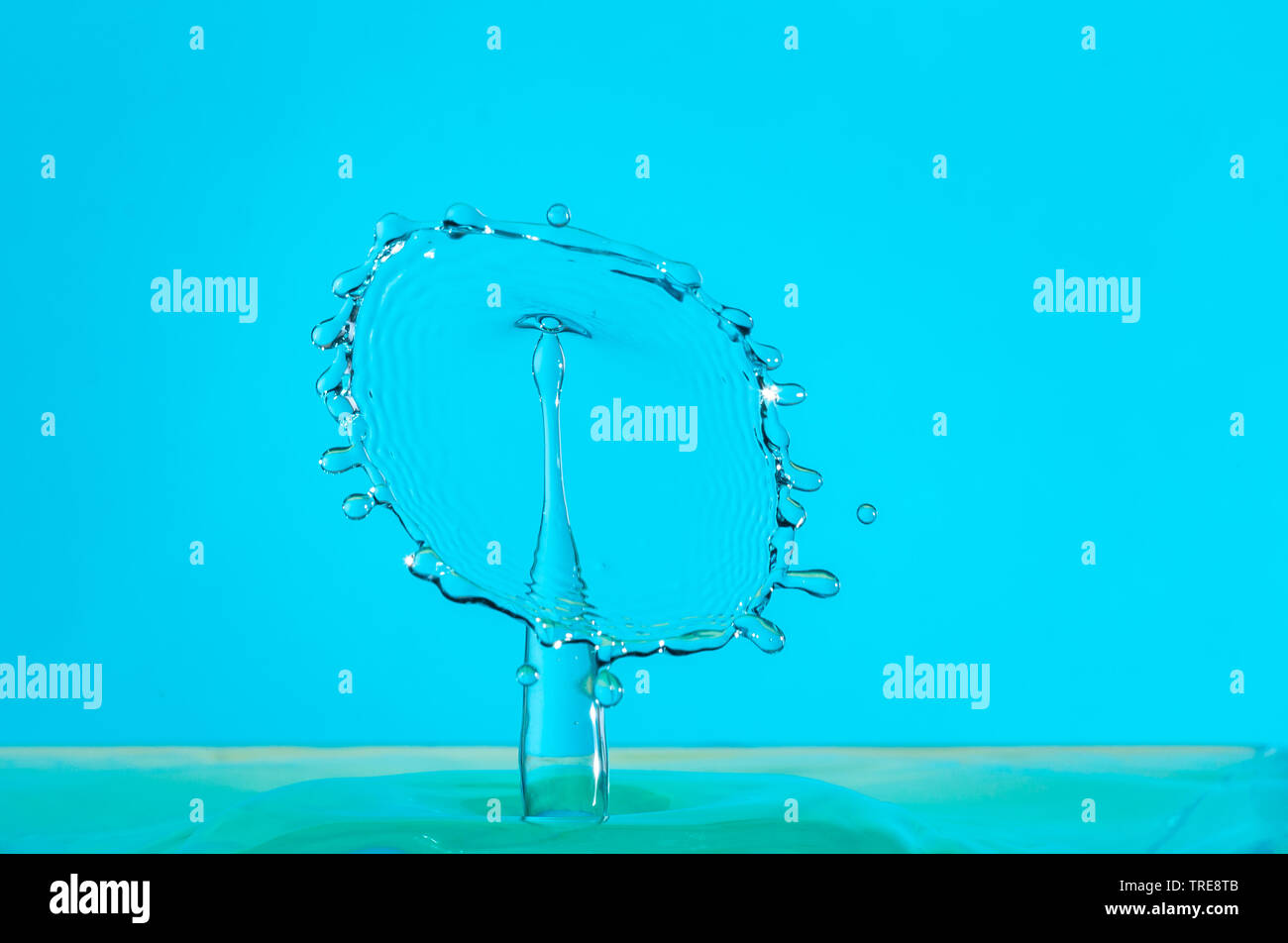 water drop falling and impacting a body of water after hitting the ...